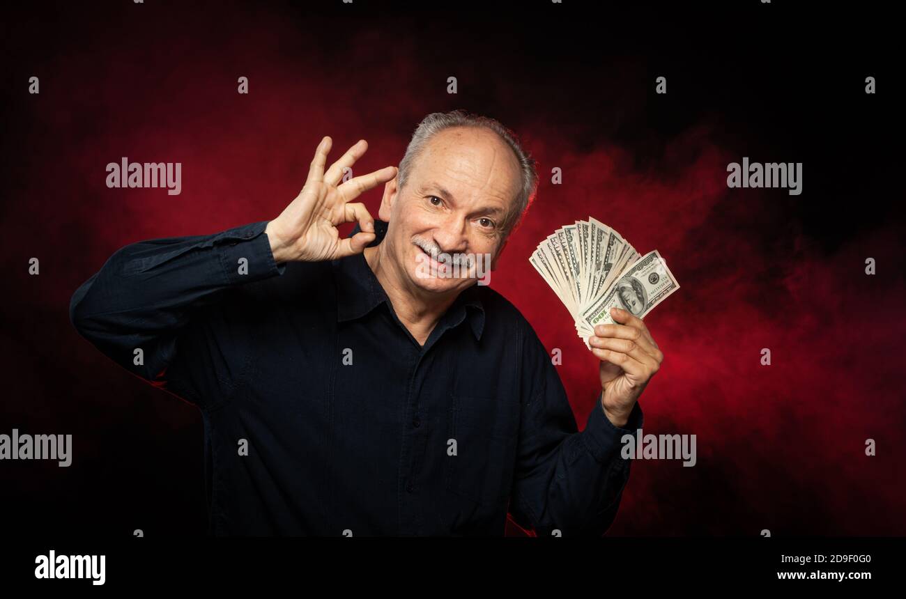 Senior gentleman holding a stack of money. Portrait of an excited old ...