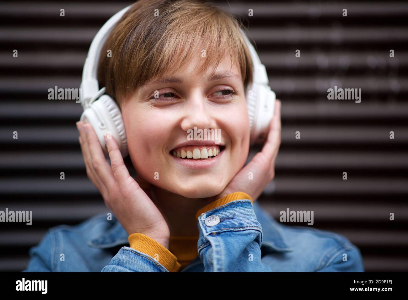 Close up portrait young woman smiling while listening to music with ...