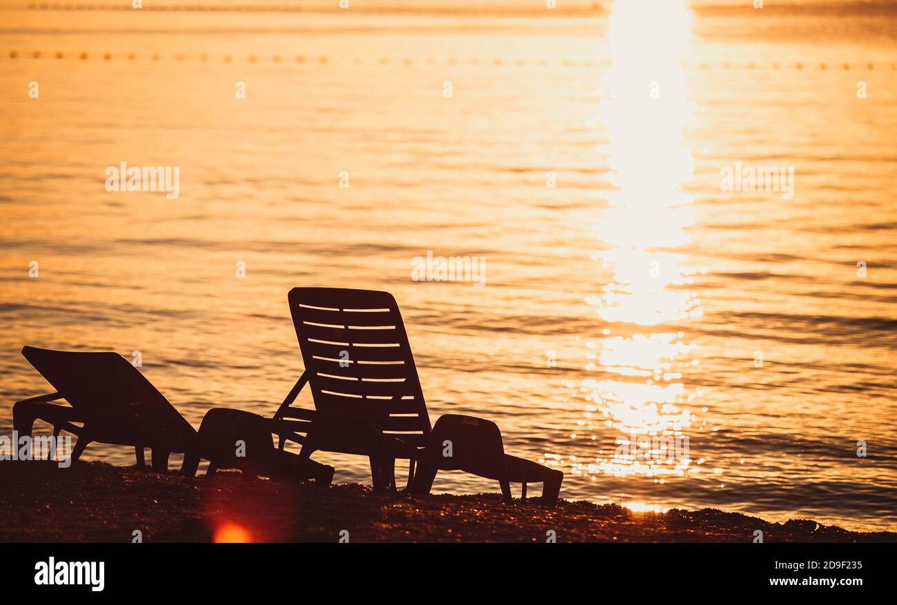 Comfortable sunbeds on beach at sunset.Golden hour lighting.Travel ...