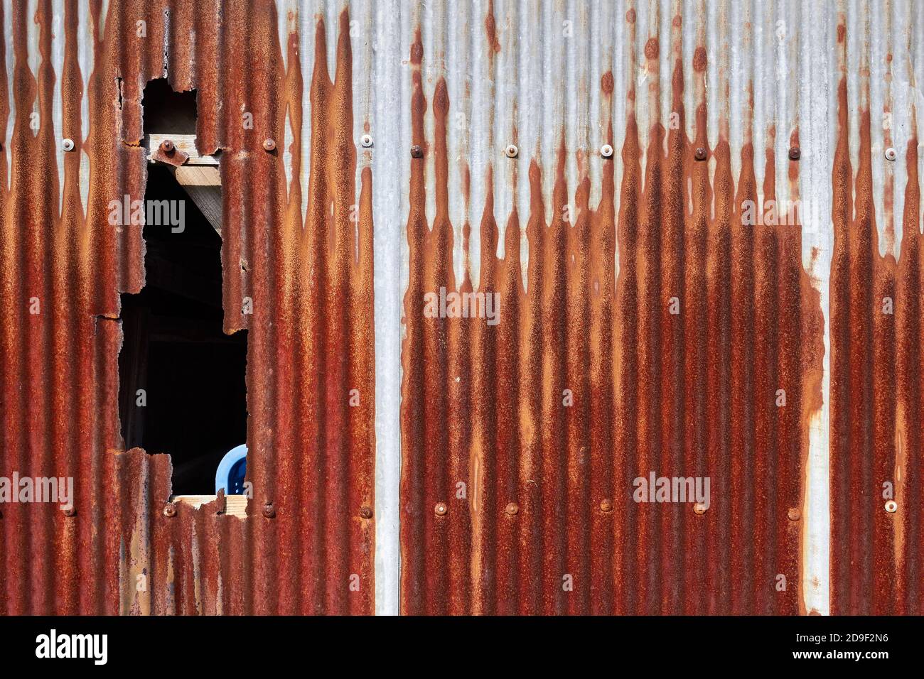 Rusty corrugated metal wall with hole Stock Photo - Alamy
