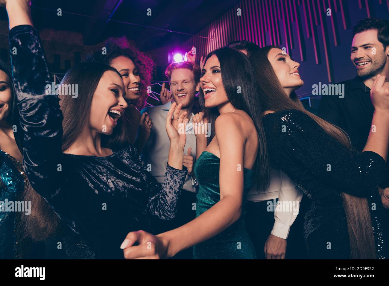 Photo of young people dancing in night club with neon lights chilling ...