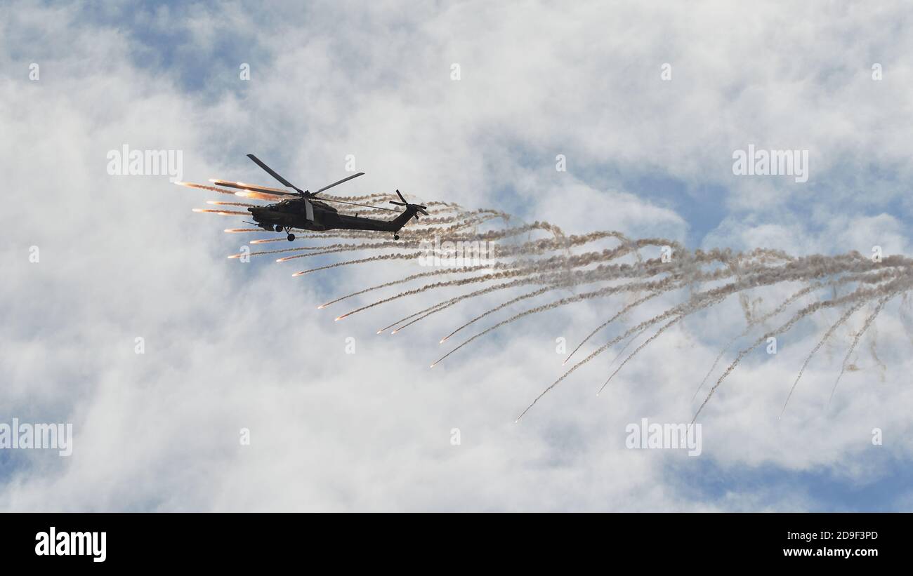 Combat helicopter Mi-28 releases a fan of heat traps.Aviation show at ...