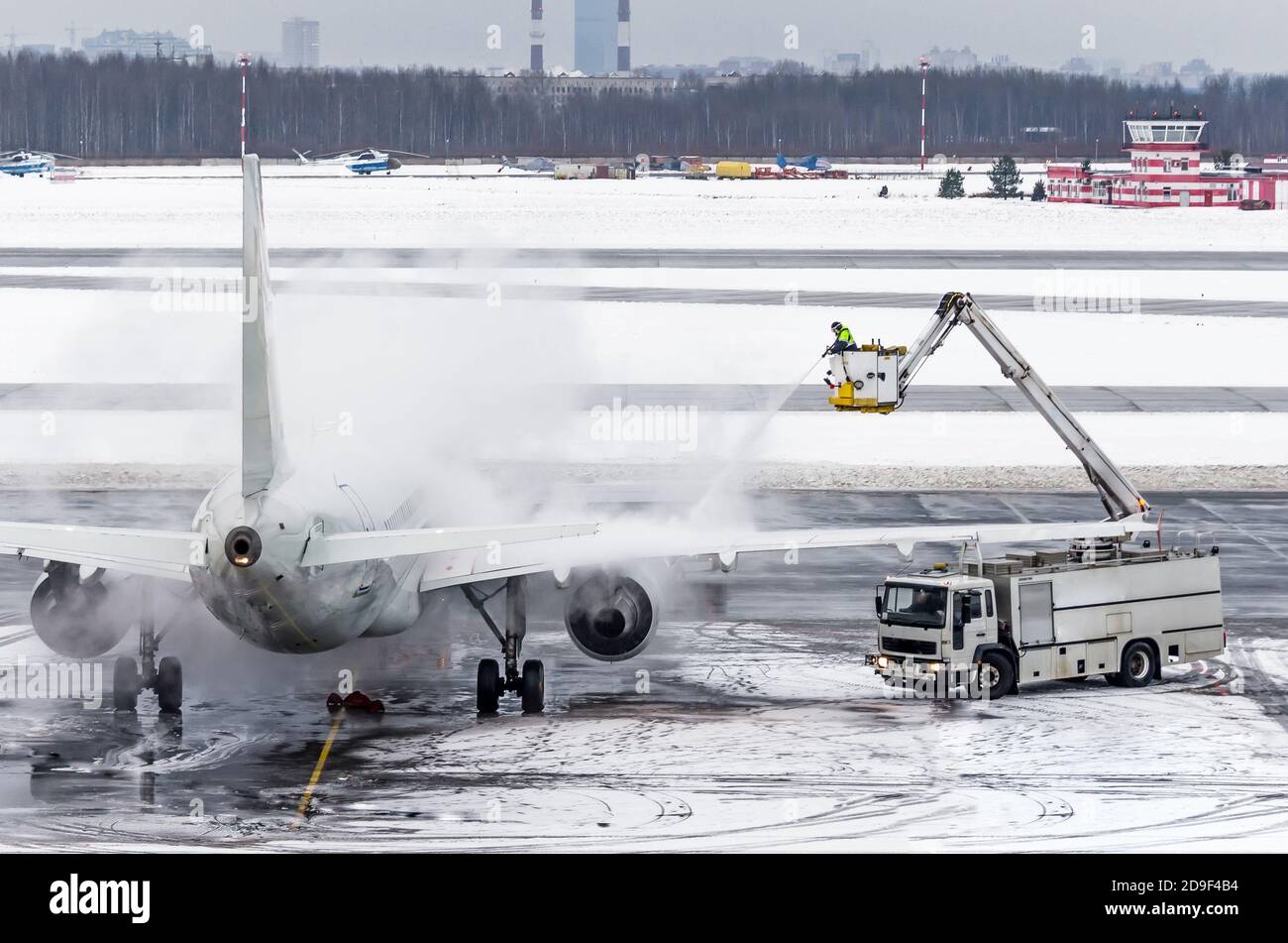 Ground crew provides de icing. They are spraying the aircraft, which ...