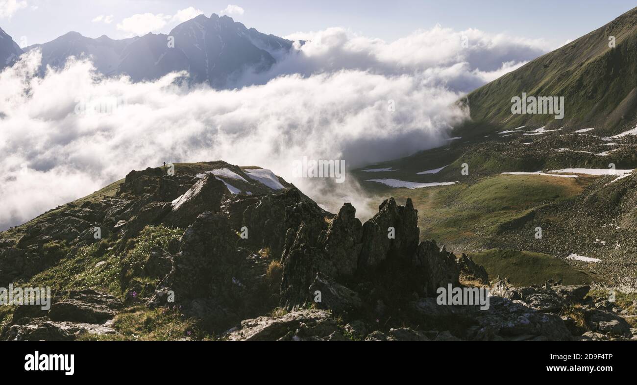 Beautiful picturesque view of tourist standing on edge of mountain with ...