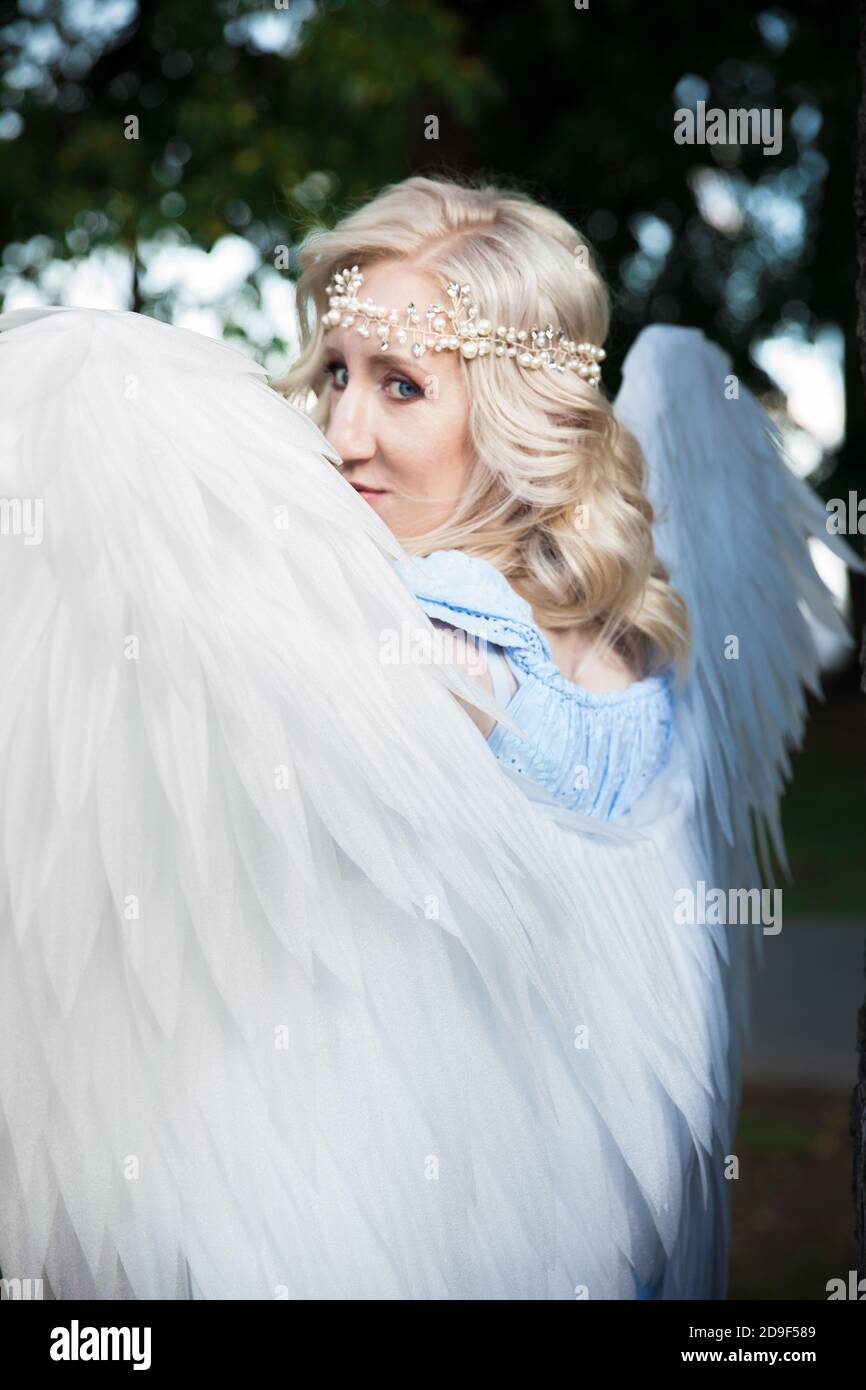 Angel girl with large white feather wings Stock Photo - Alamy