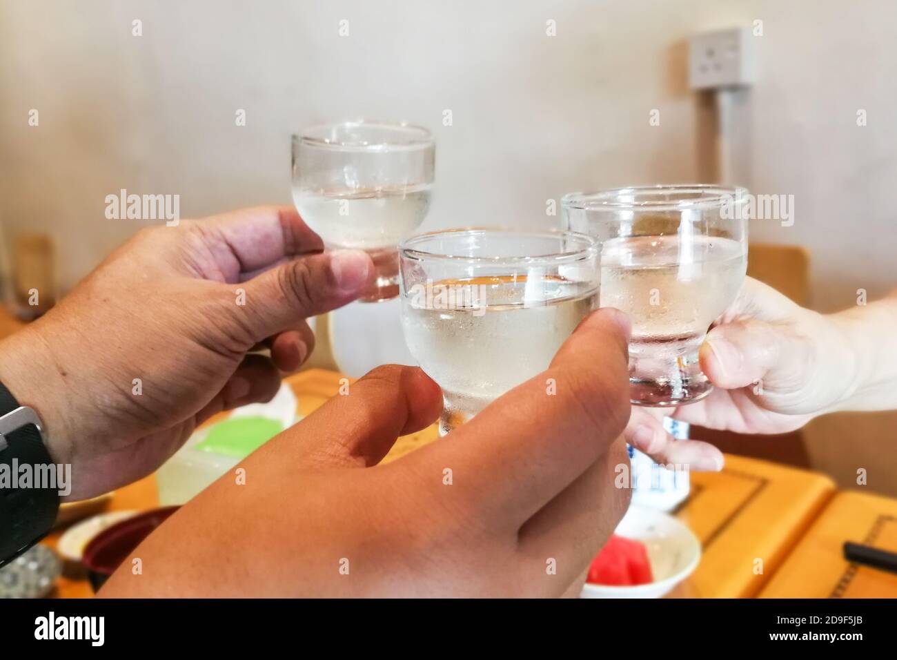 Three people toasting Japanese sake in restaurant Stock Photo - Alamy