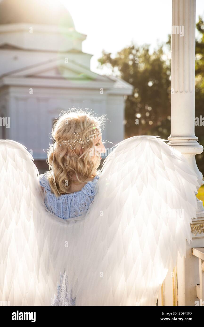 Angel girl with large white feather wings Stock Photo - Alamy
