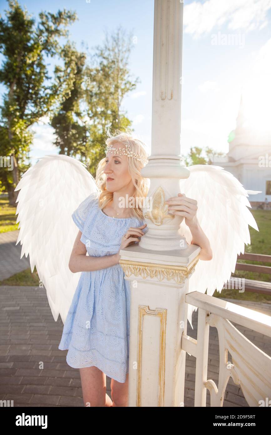 Angel girl with large white feather wings Stock Photo - Alamy