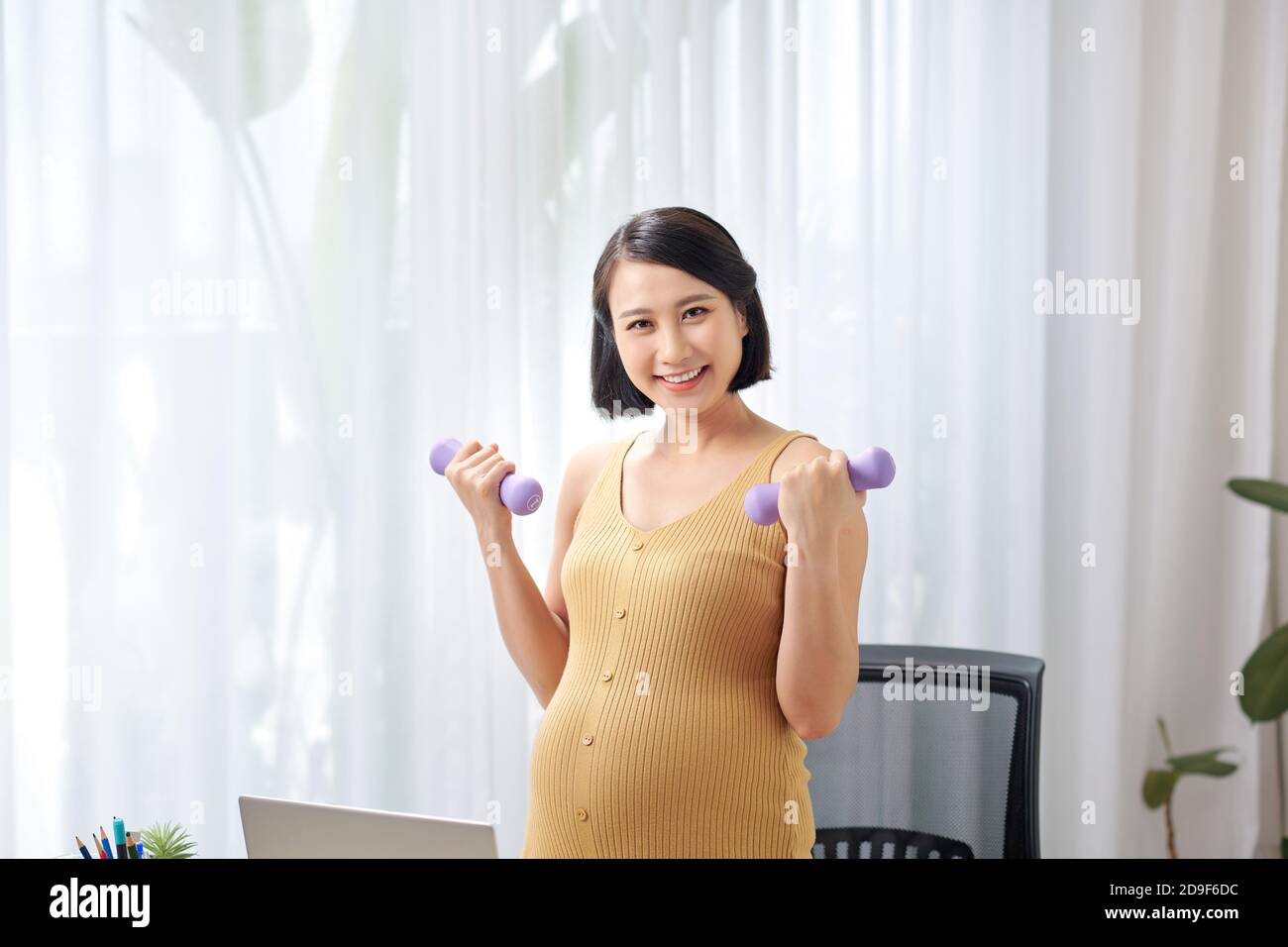 Happy pregnant woman in office being active Stock Photo - Alamy