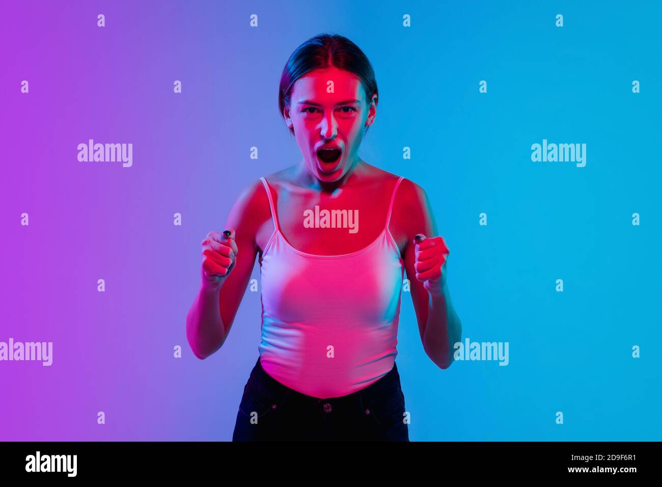 Screaming angry. Young caucasian woman's portrait on gradient blue ...