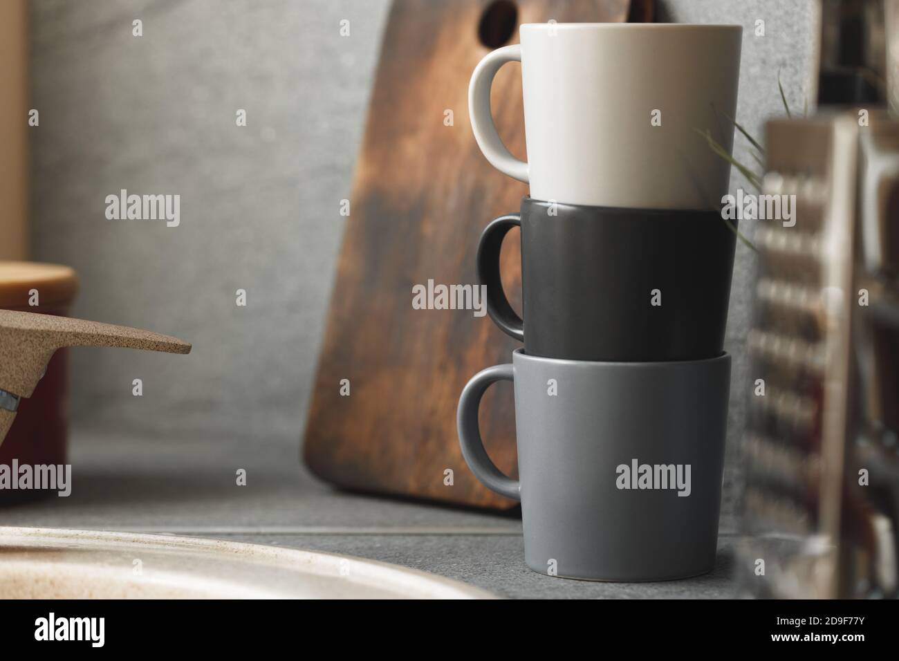 Stack of three grey cups on kitchen counter Stock Photo - Alamy