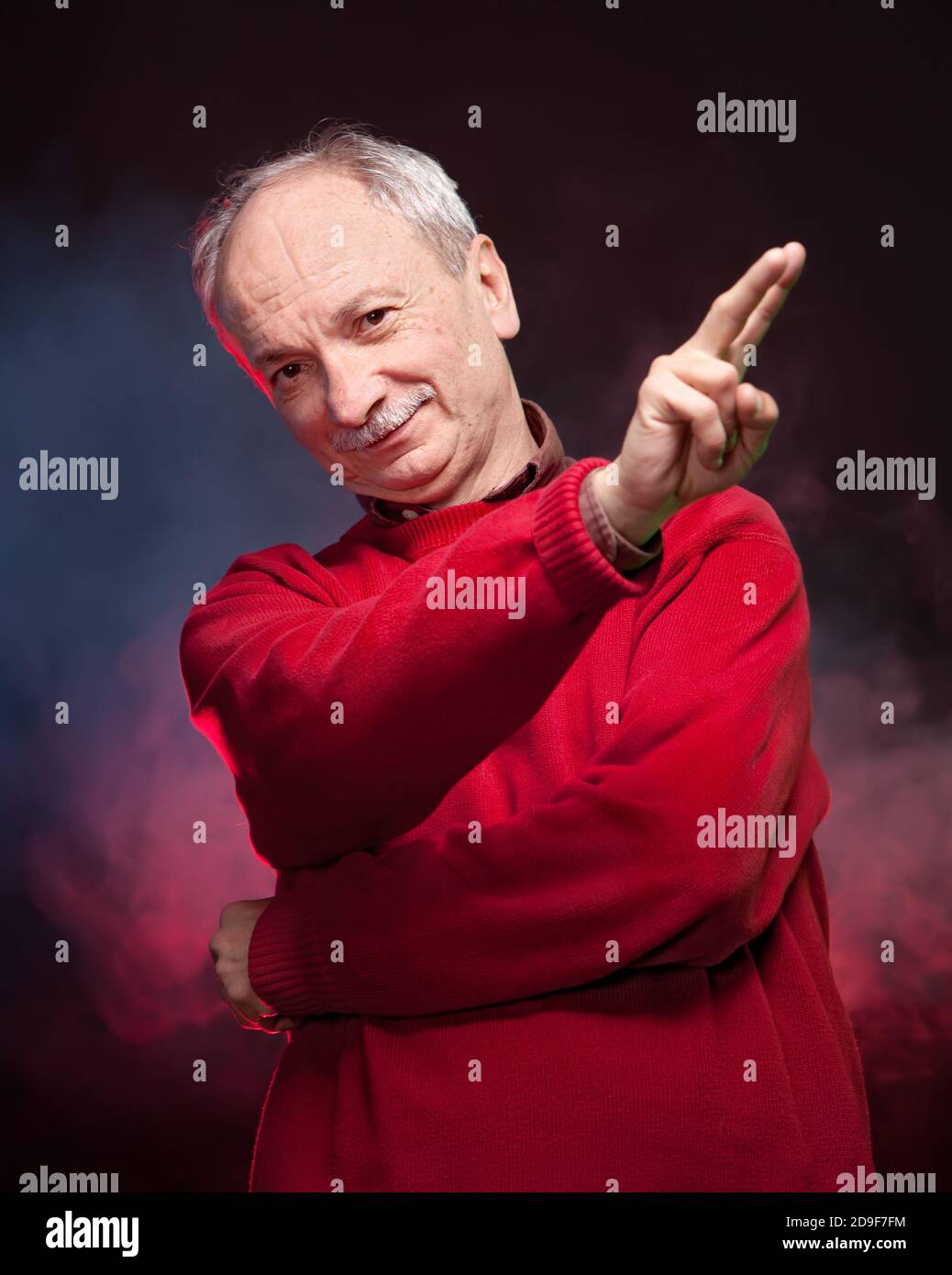 Successful old man in a red sweater gestures Stock Photo - Alamy