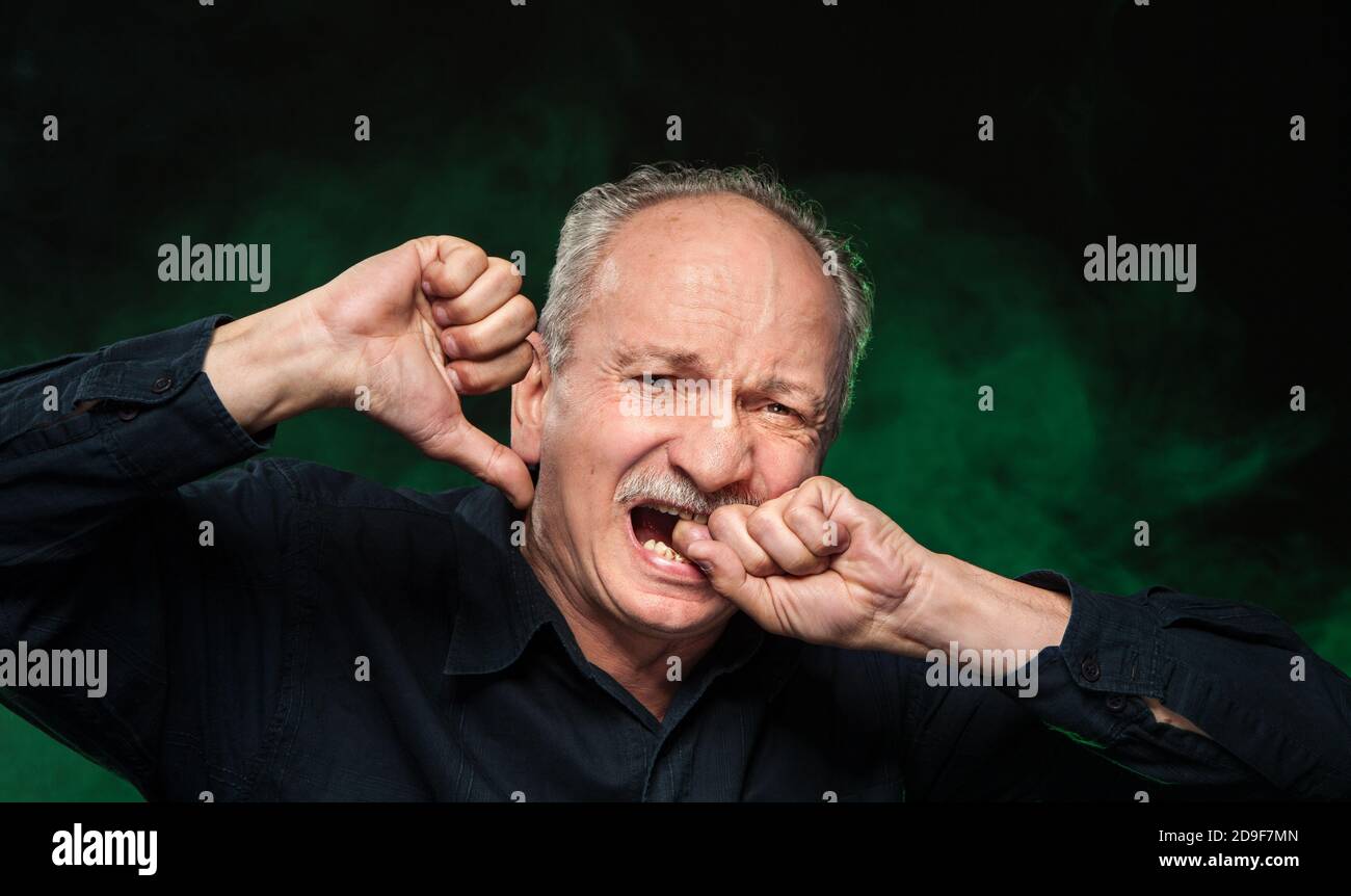 old man in despair biting his hands Stock Photo - Alamy