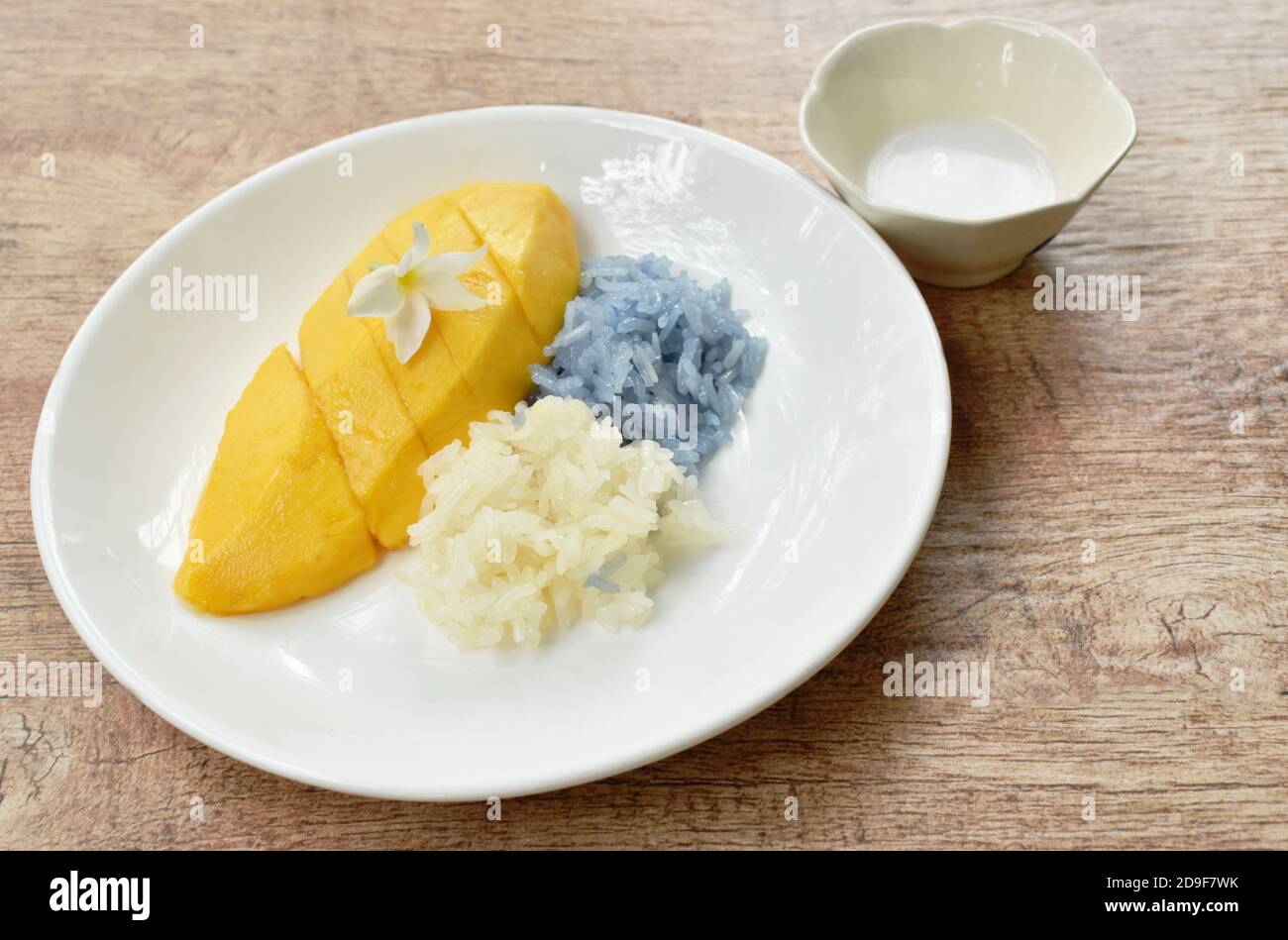 ripen mango with white and purple sticky rice dressing coconut milk on ...