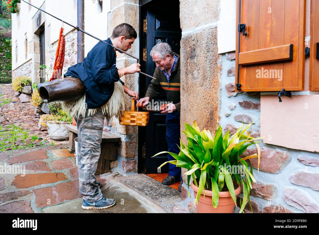 Young people from the village collect food in the houses that they will ...