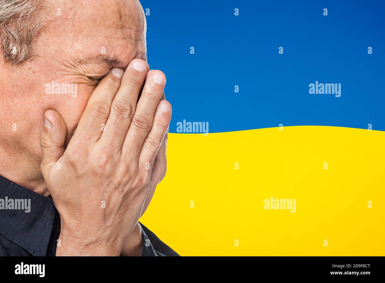 The war in Ukraine. Elderly man covered his face against of Ukrainian ...