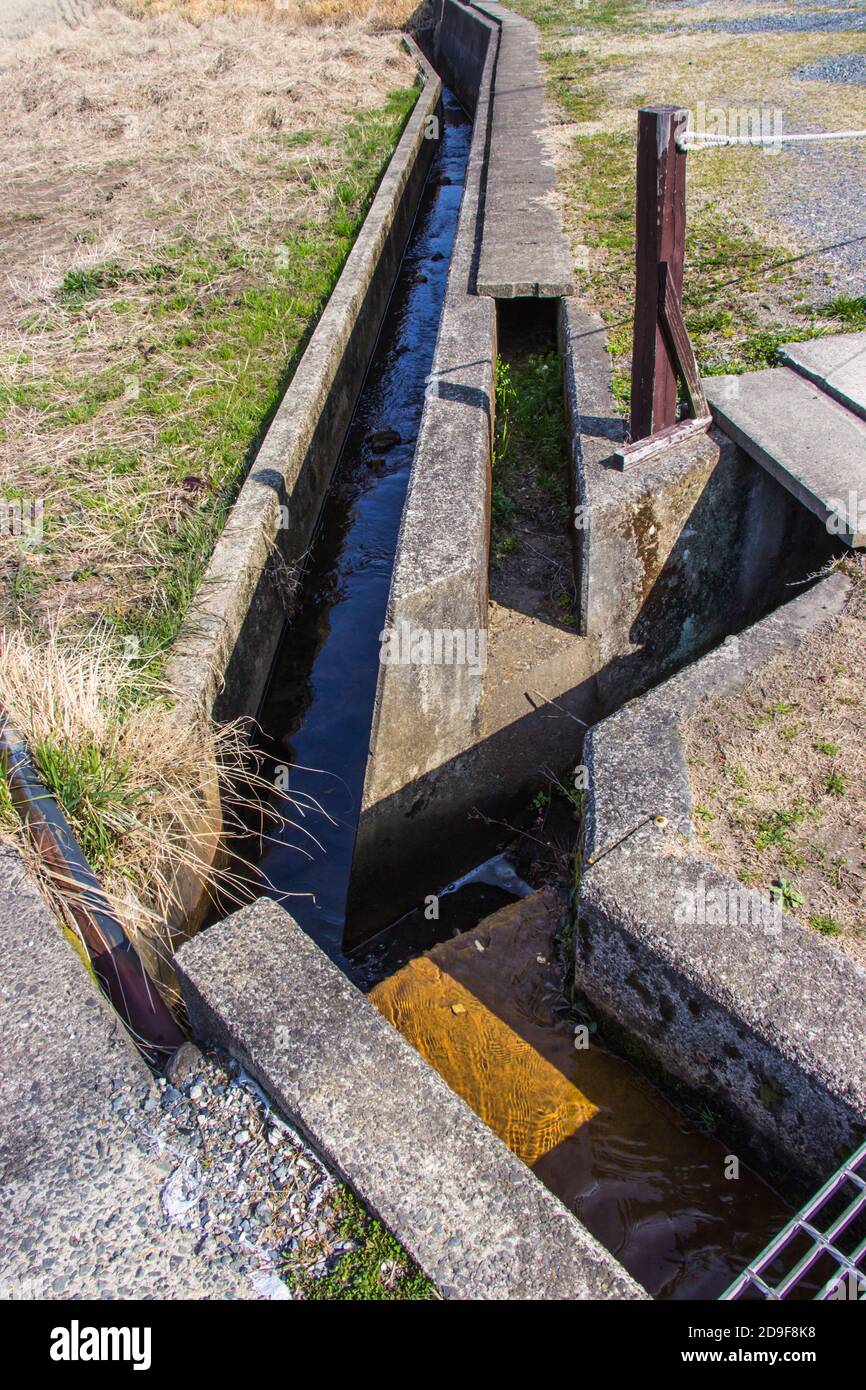 Small concrete irrigation canal in the countryside Kyoto Prefecture ...