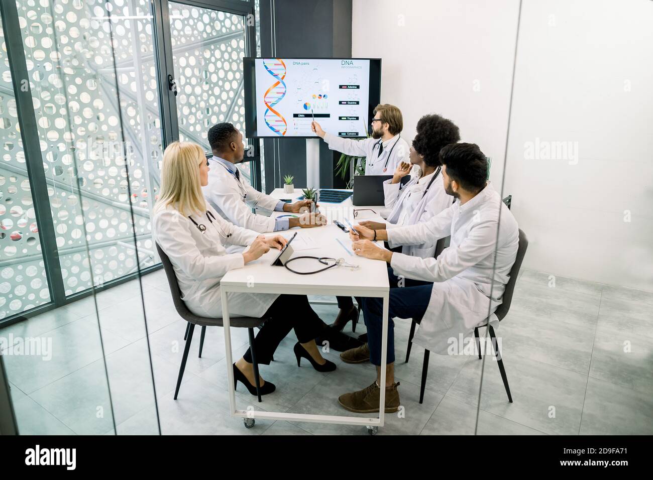 Team of five multiracial male and female doctors having brainstorming ...