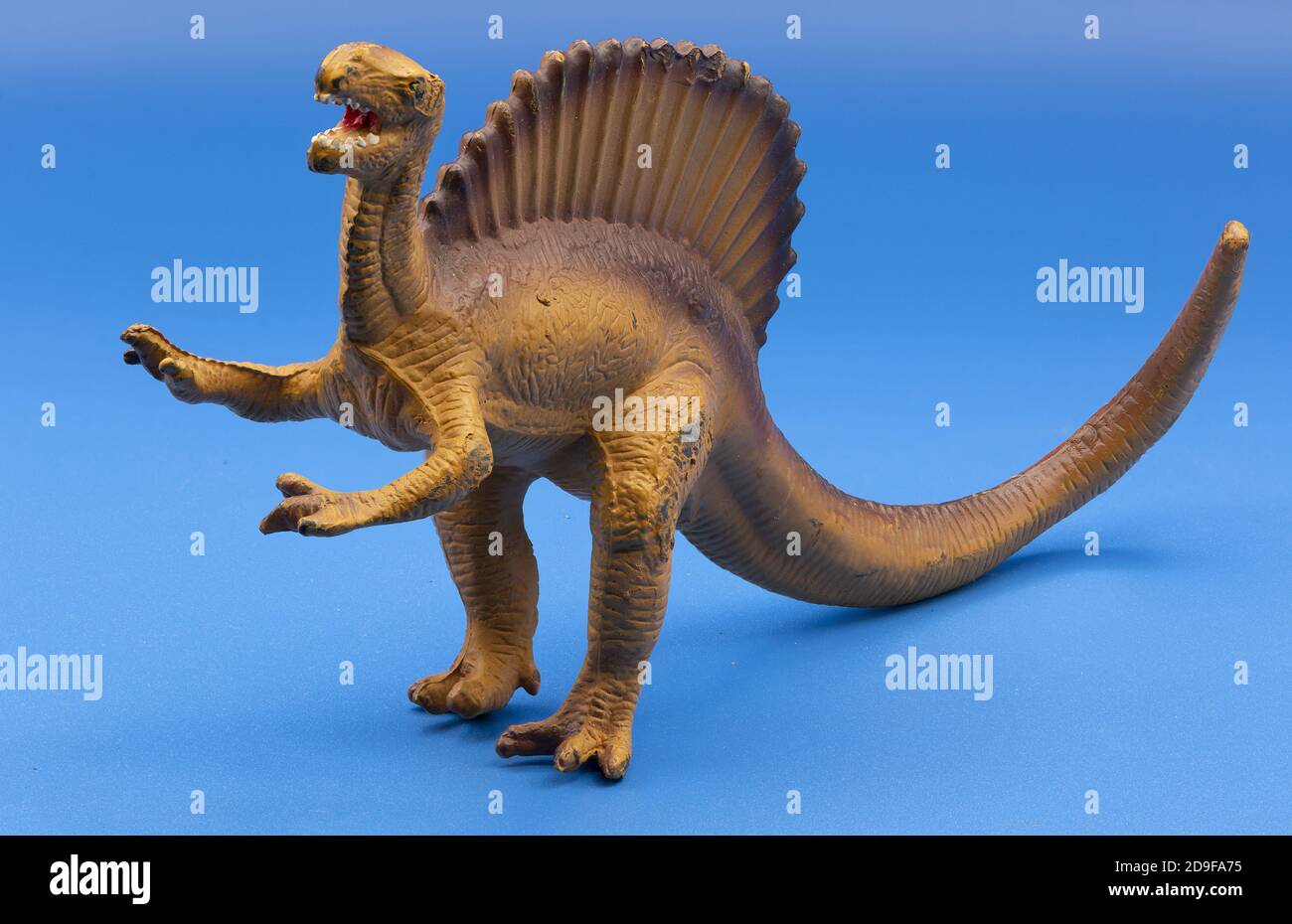 Spinosaurus's toy isolated on a blue surface Stock Photo - Alamy