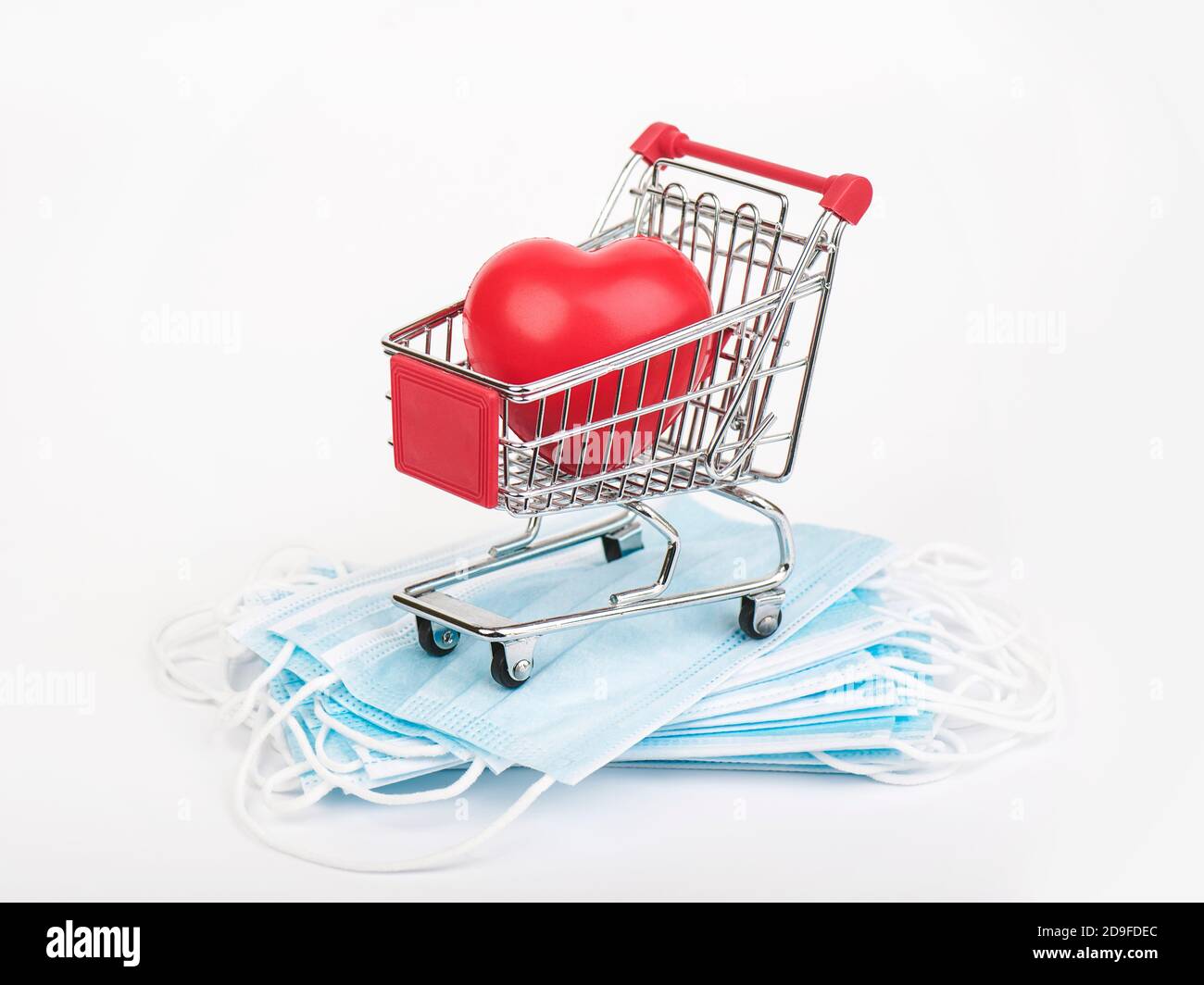 Covid 19 concept.shopping cart with pile of medical face masks and red ...