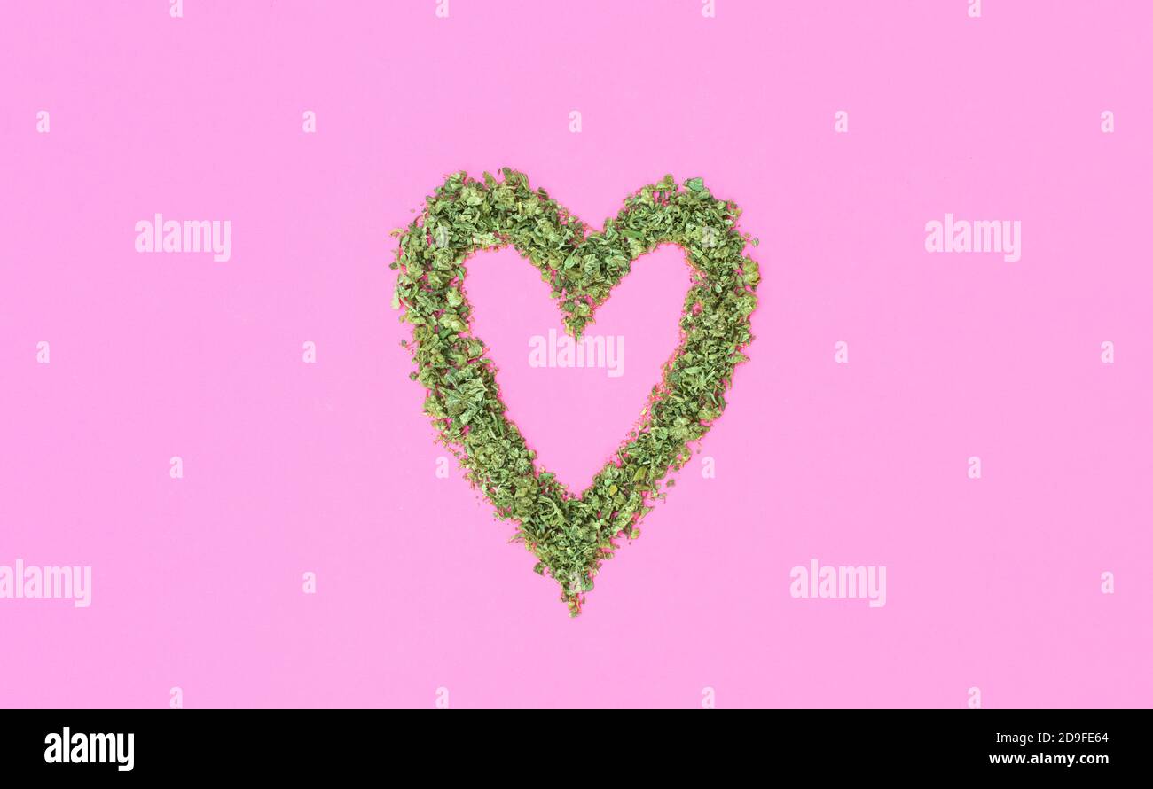 Heart made with marijuana on pink background. Weed and love concept ...
