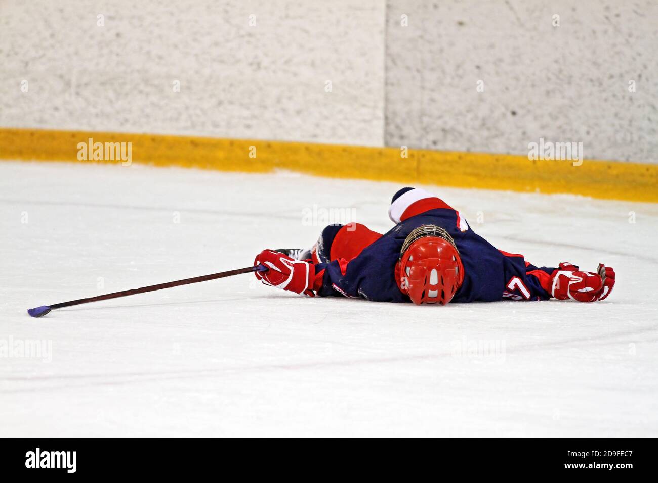 Hockey player lying on ice rink Stock Photo - Alamy