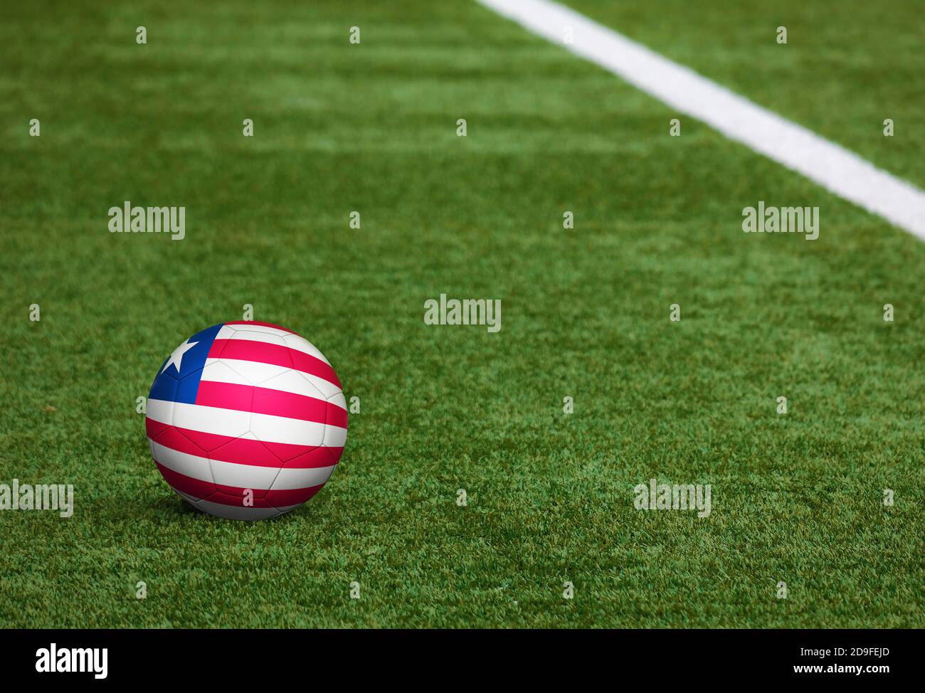 Liberia flag on ball at soccer field background. National football ...
