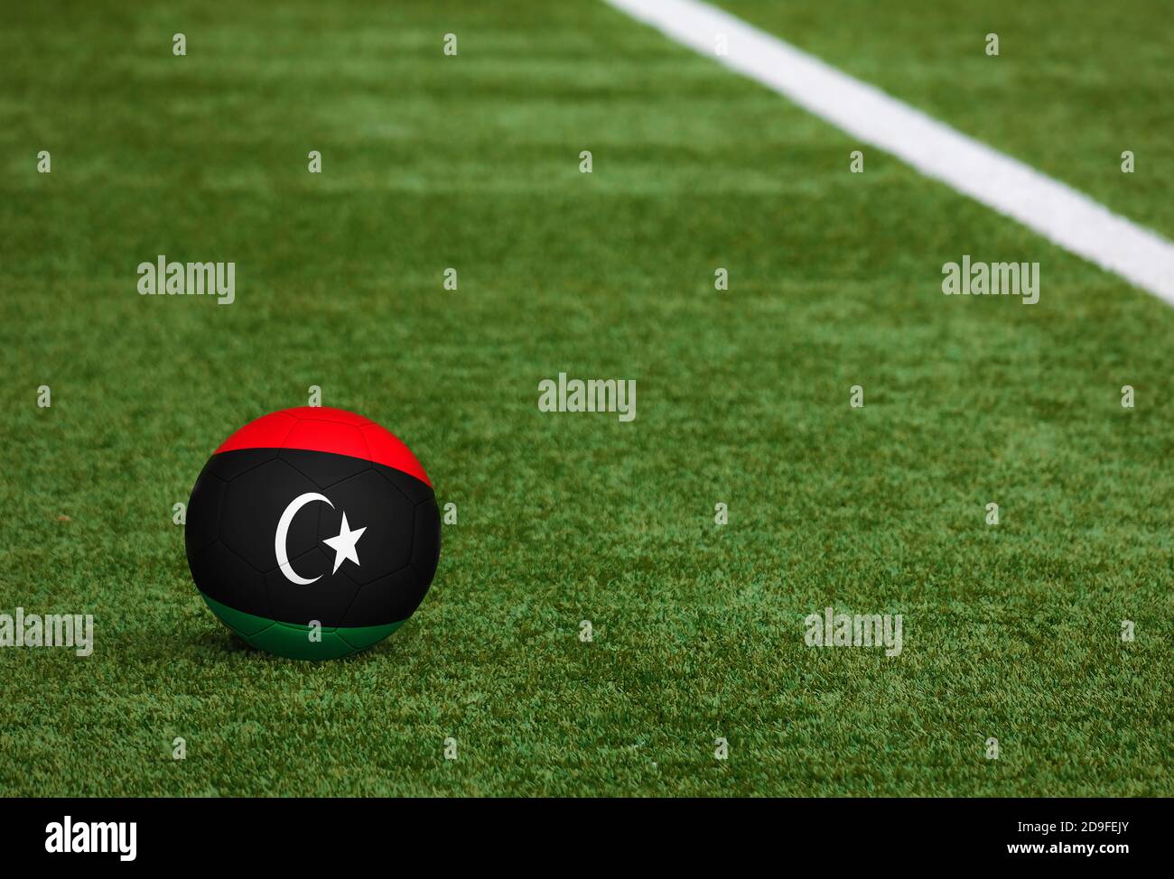 Libya flag on ball at soccer field background. National football theme ...