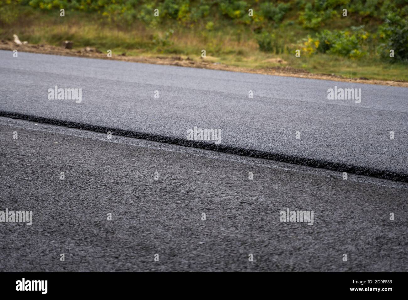 A large layer of fresh hot asphalt. Layer of asphalt raw material in a ...