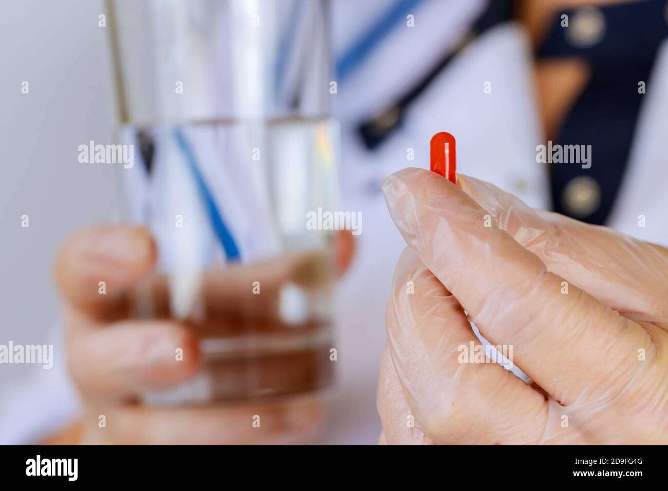 Woman doctor holding red pill in hands Stock Photo - Alamy