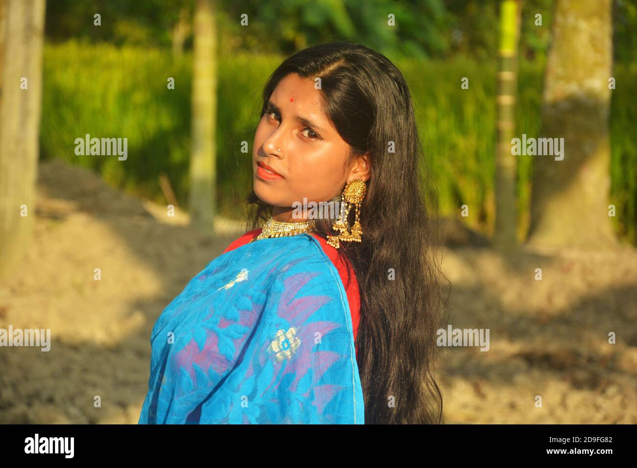 Close up of teenage Indian Bengali girl wearing blue sari with long ...