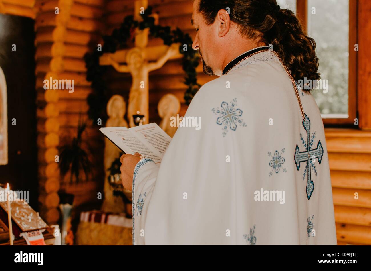 priest in cassock holds holy book of Bible and reads Stock Photo - Alamy