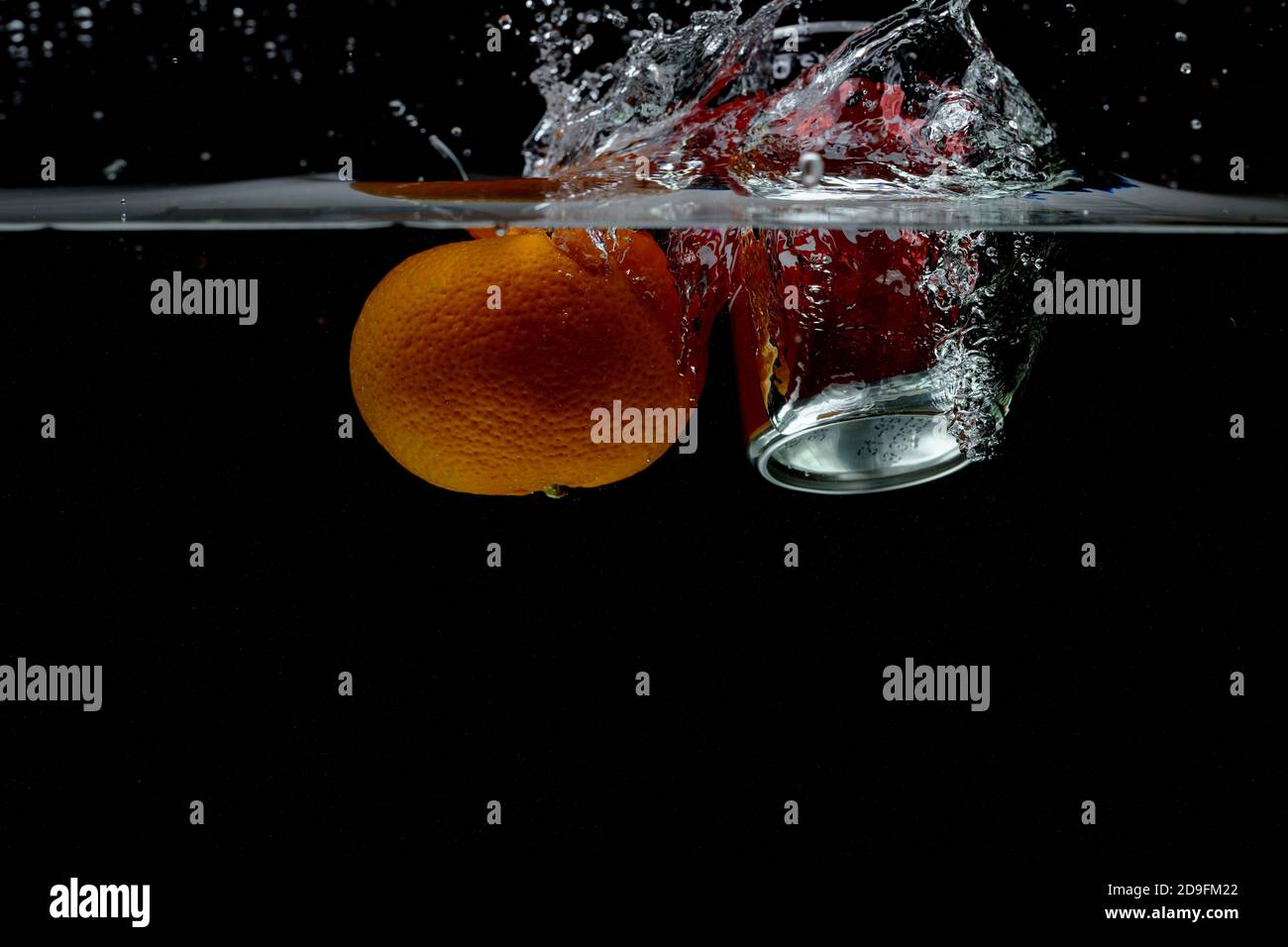 Beautiful view of mandarin and soda jar falling in water and floating ...