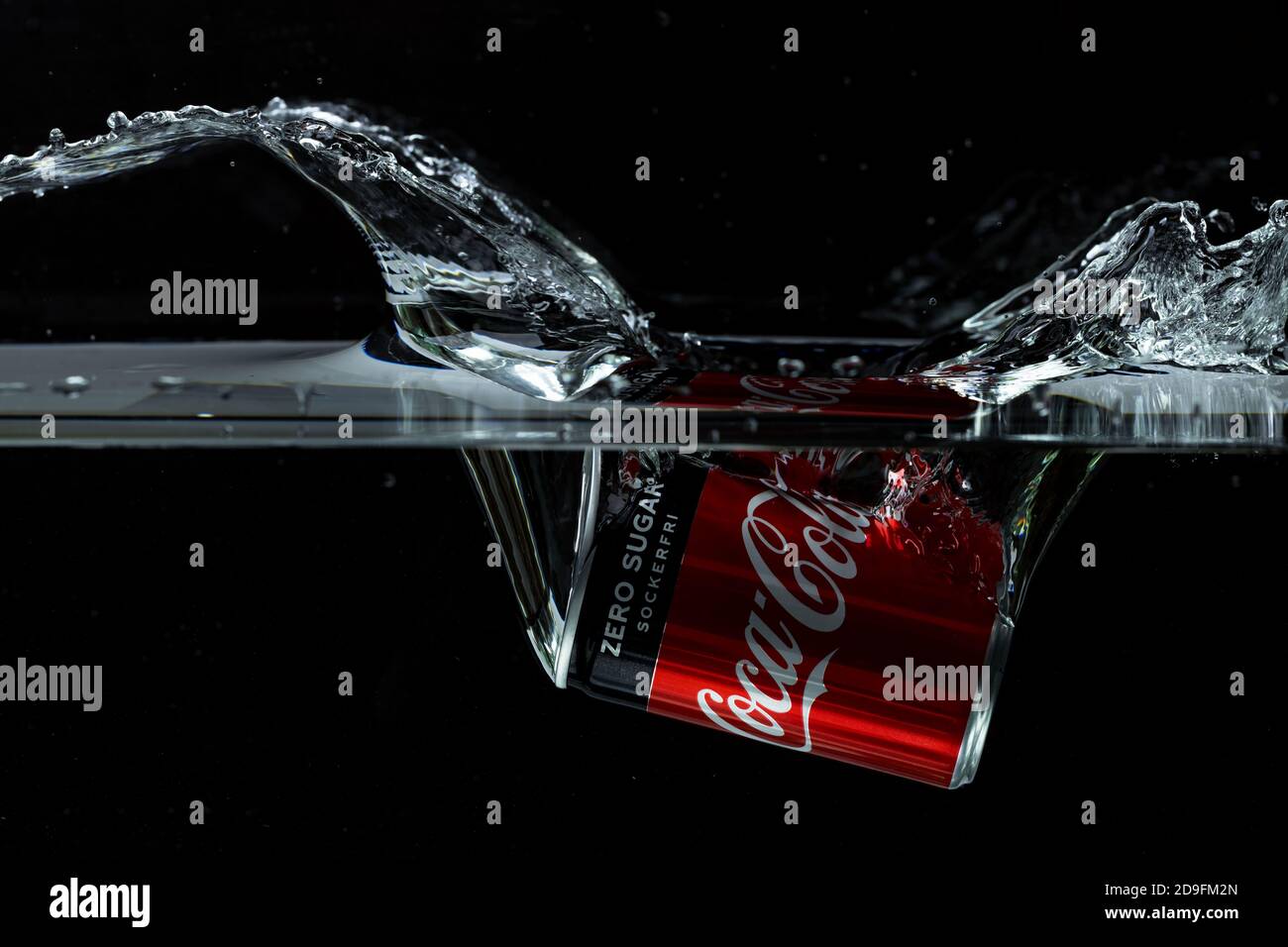 Close up view of coca cola falling in water on black background ...