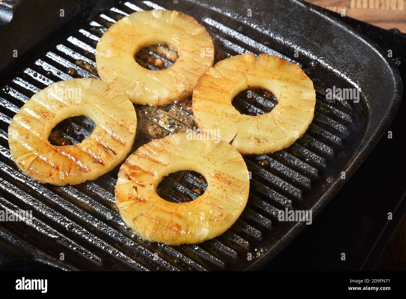 Grilled pineapple rings on a cast iron grill Stock Photo - Alamy