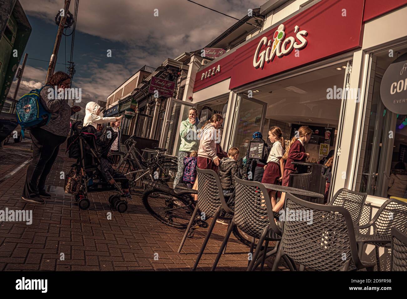 Everyday life. People queuing to local pizzeria at Main Street in ...