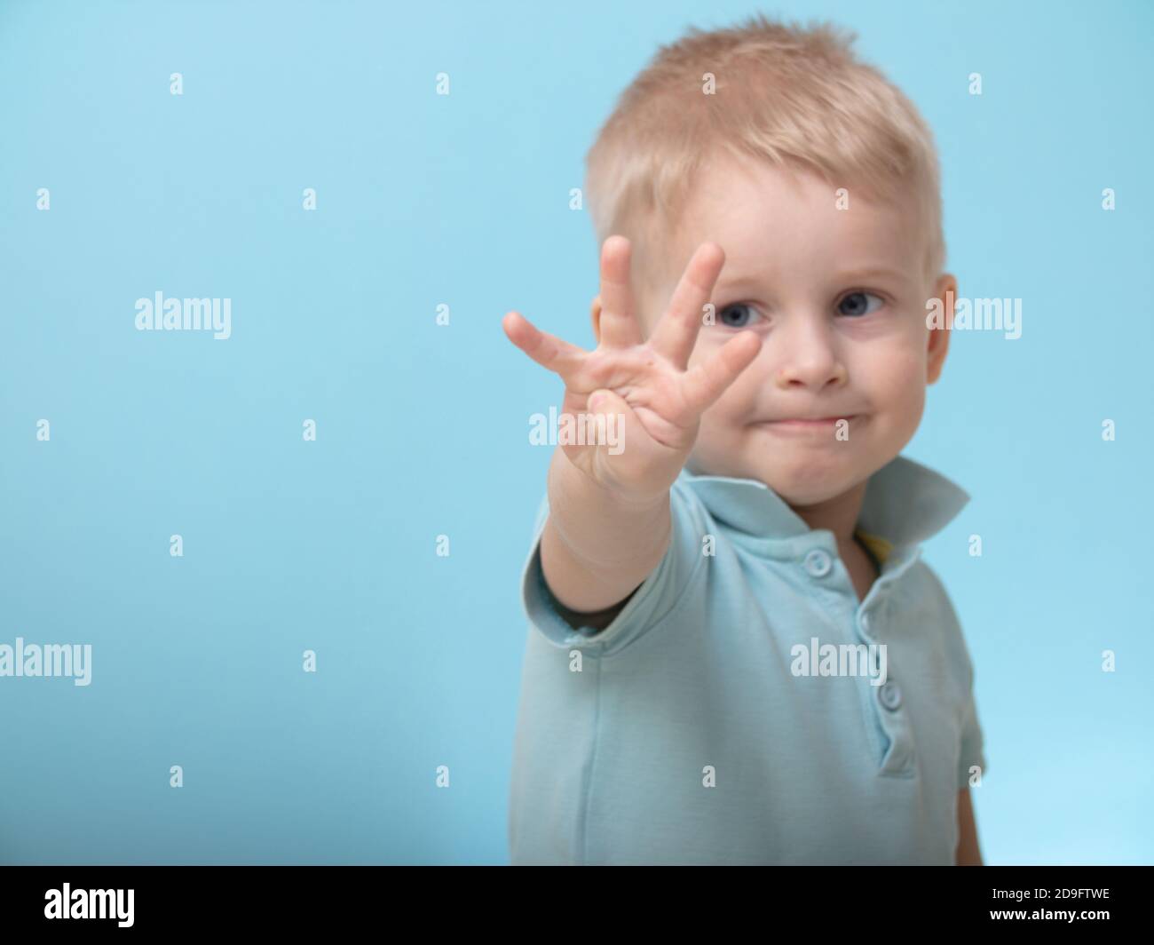 the baby shows on his fingers that he is four years old. concept of ...