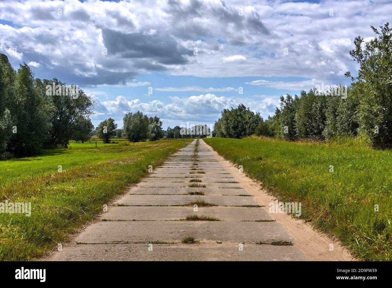 Concrete slab road along pasture in rural area Stock Photo - Alamy