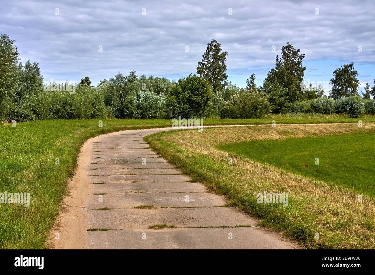 Concrete slab road along pasture in rural area Stock Photo - Alamy