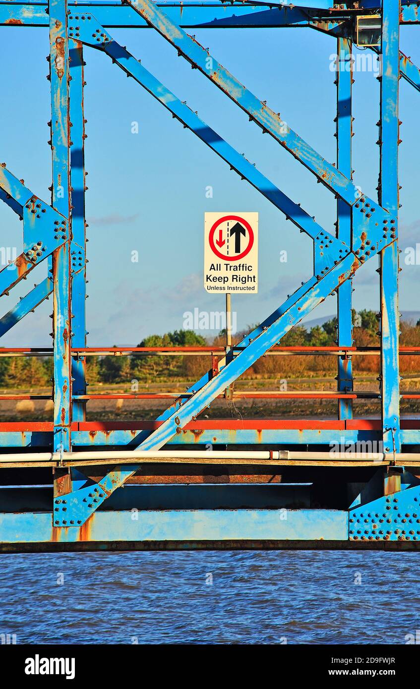 Traffic directions sign on rusting blue bridge over water Stock Photo ...