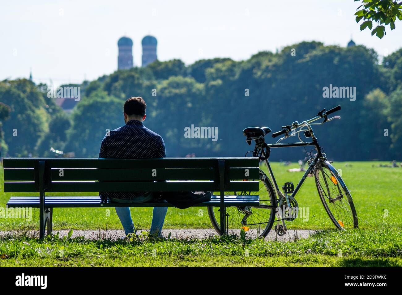 Man on park bench with bicycle Stock Photo - Alamy