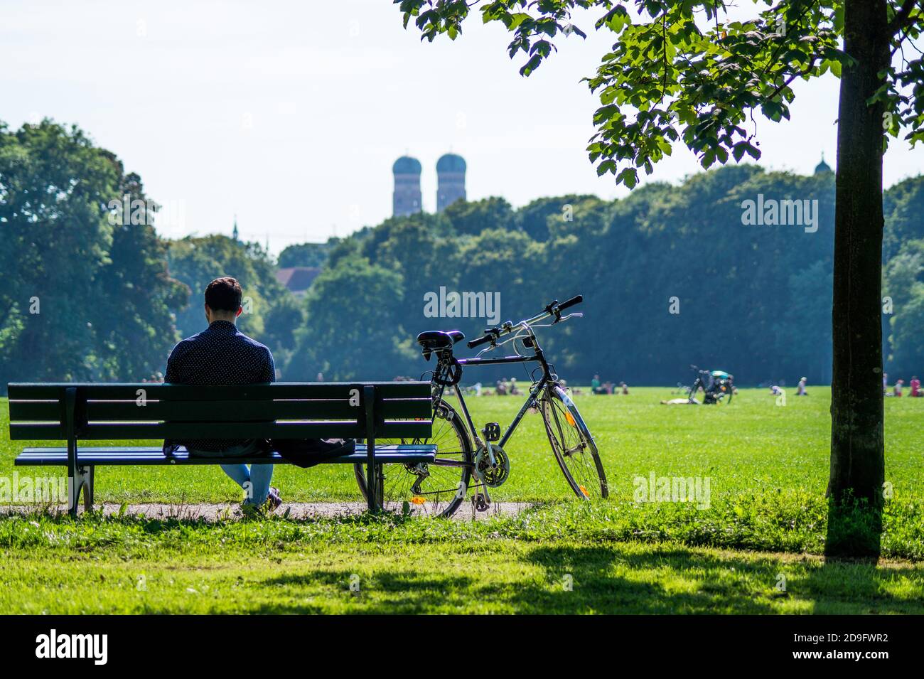Man on park bench with bicycle Stock Photo - Alamy
