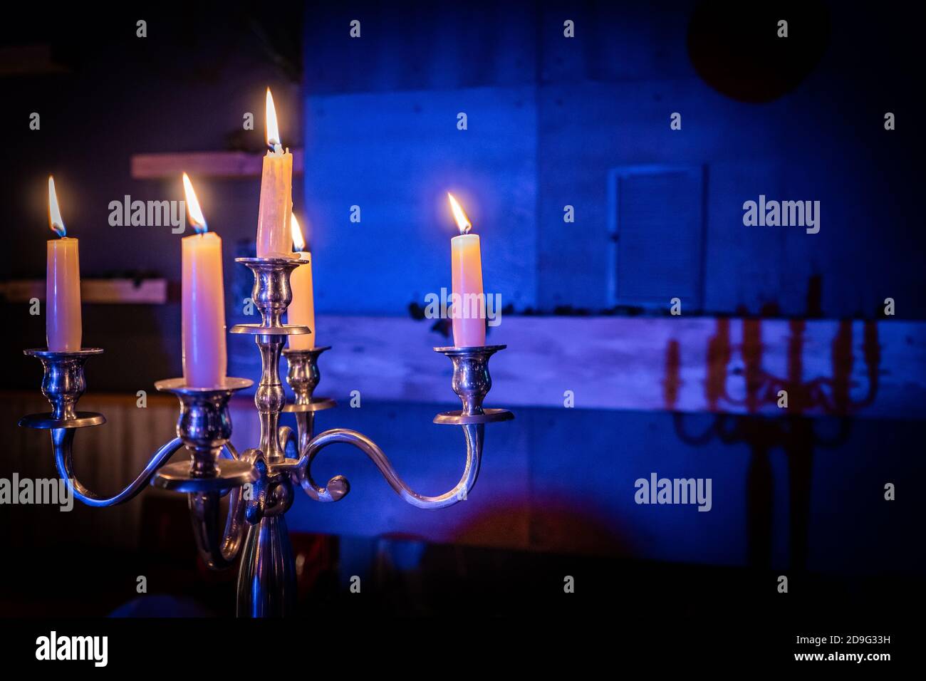 candles burning with blue background light Stock Photo - Alamy