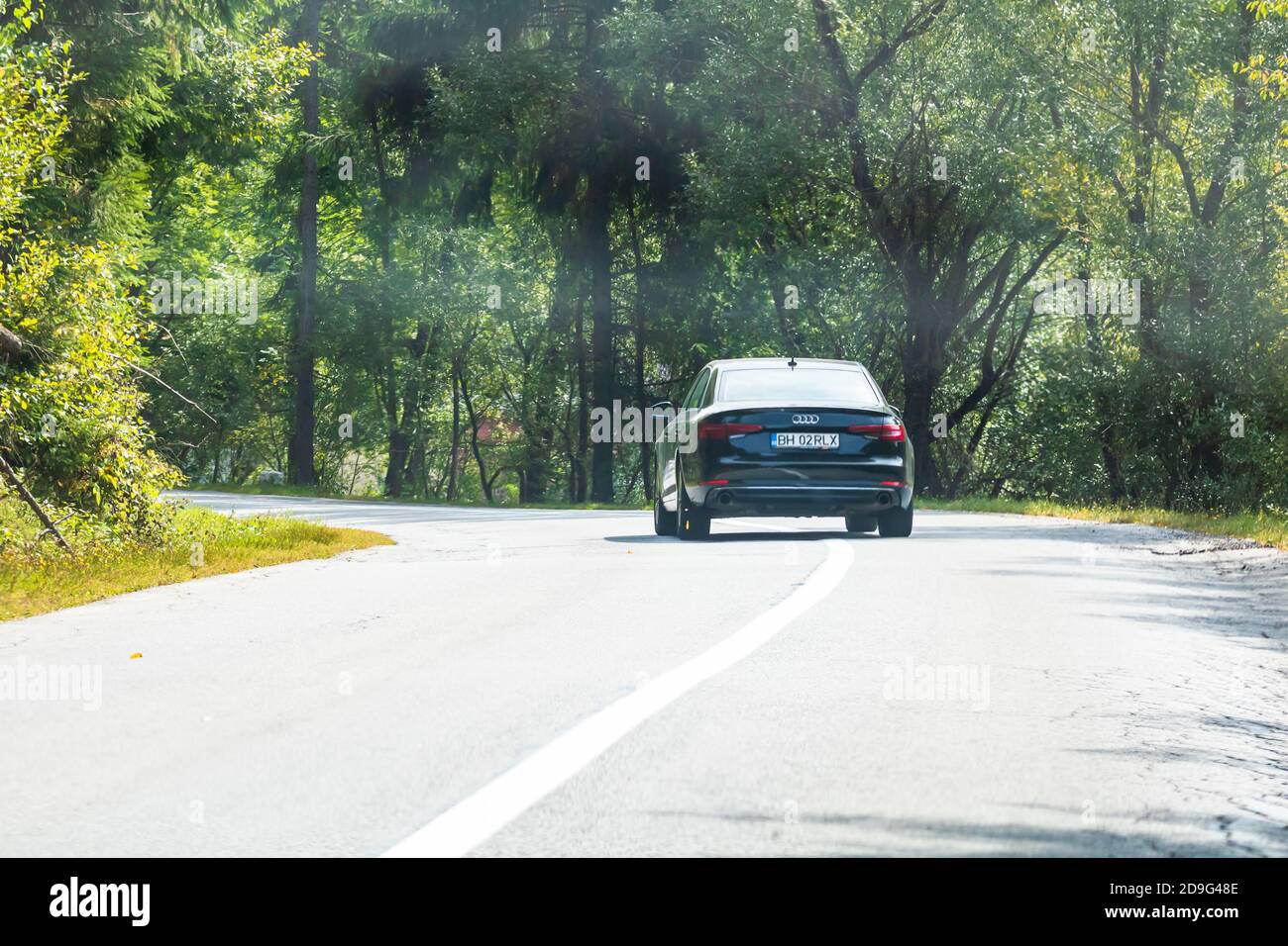Traveling black car in motion on asphalt road, back view of car on ...