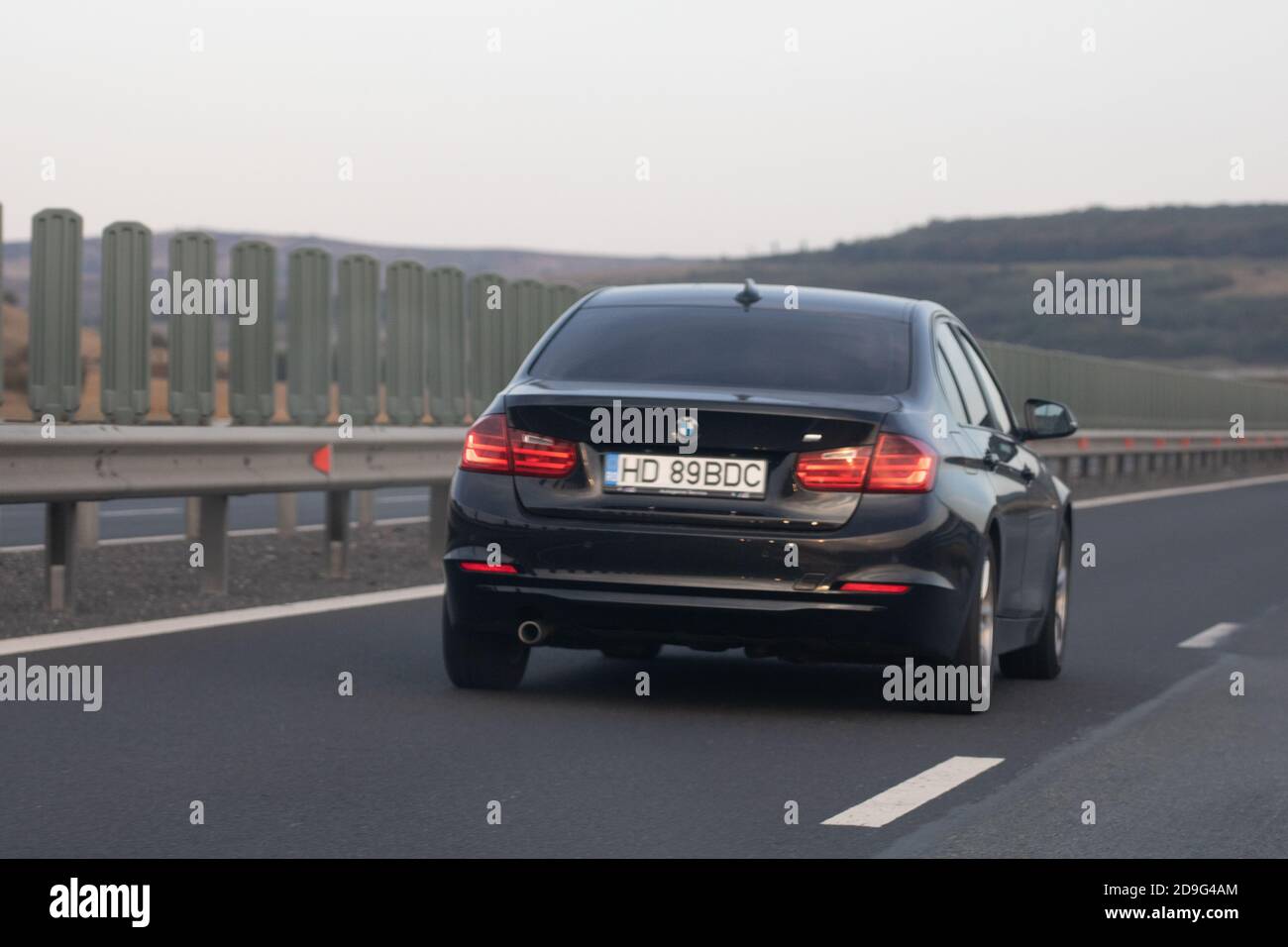 Traveling BMW car in motion on asphalt road, back view of car on street ...