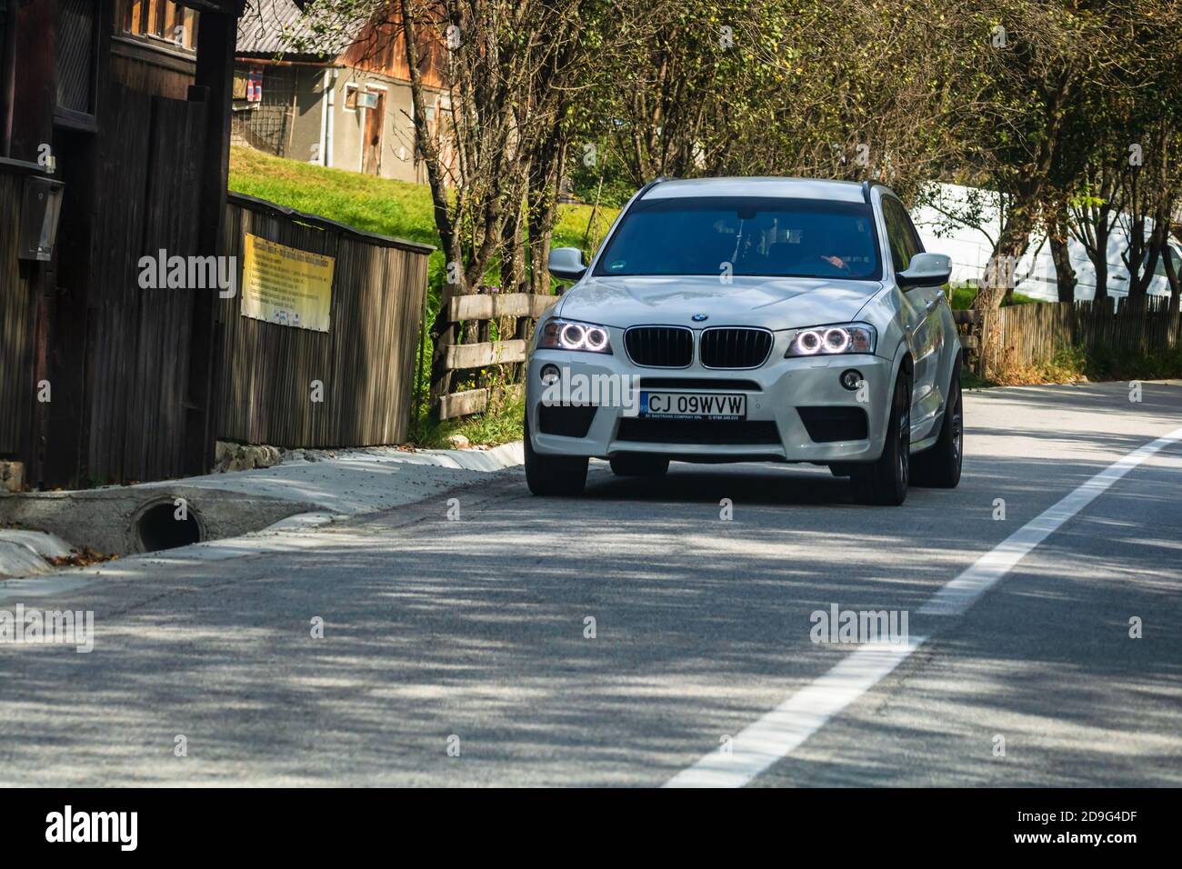 Traveling white BMW car in motion on asphalt road, front view of car on ...