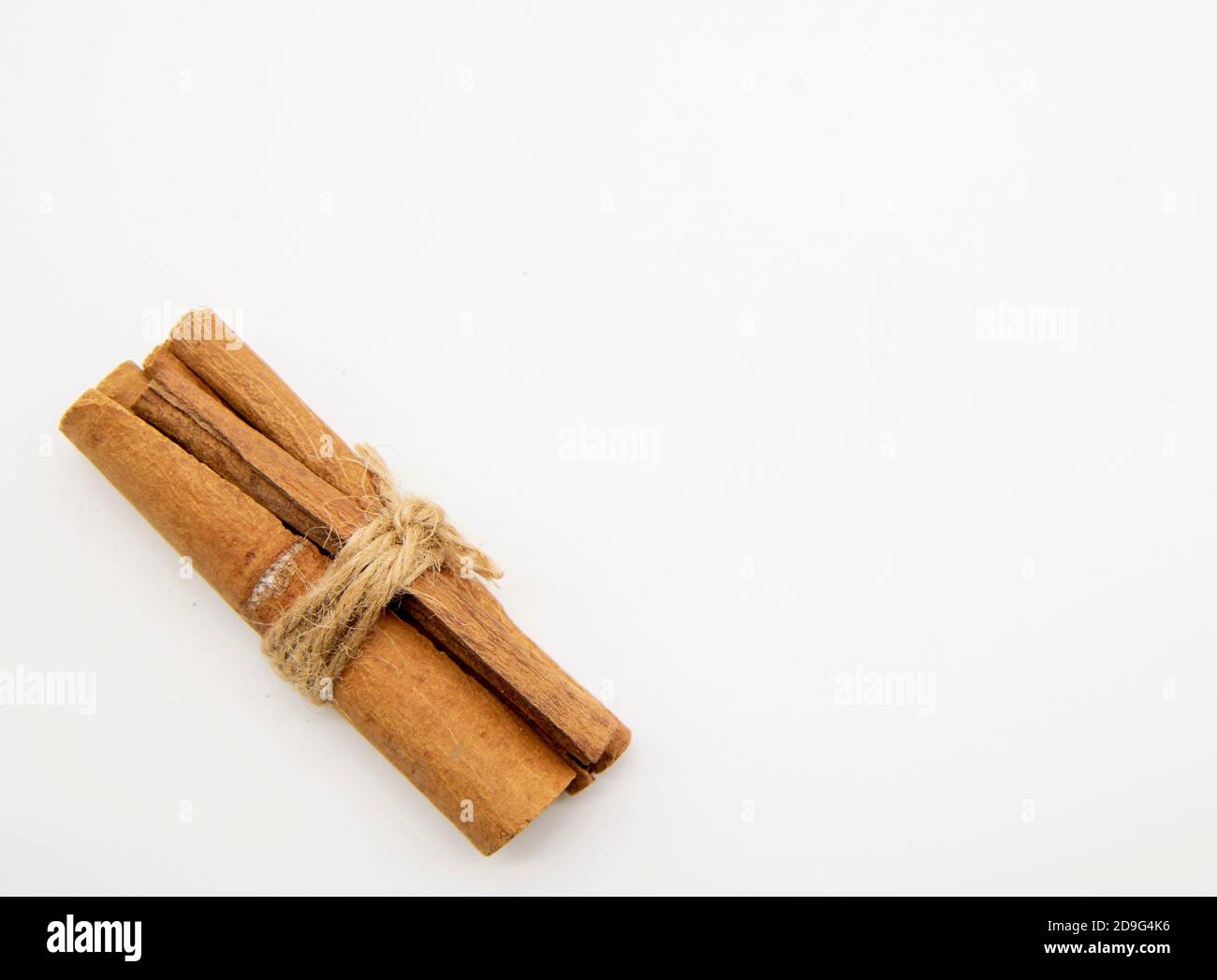 Cinnamon sticks tied with a cord on a white background Stock Photo - Alamy