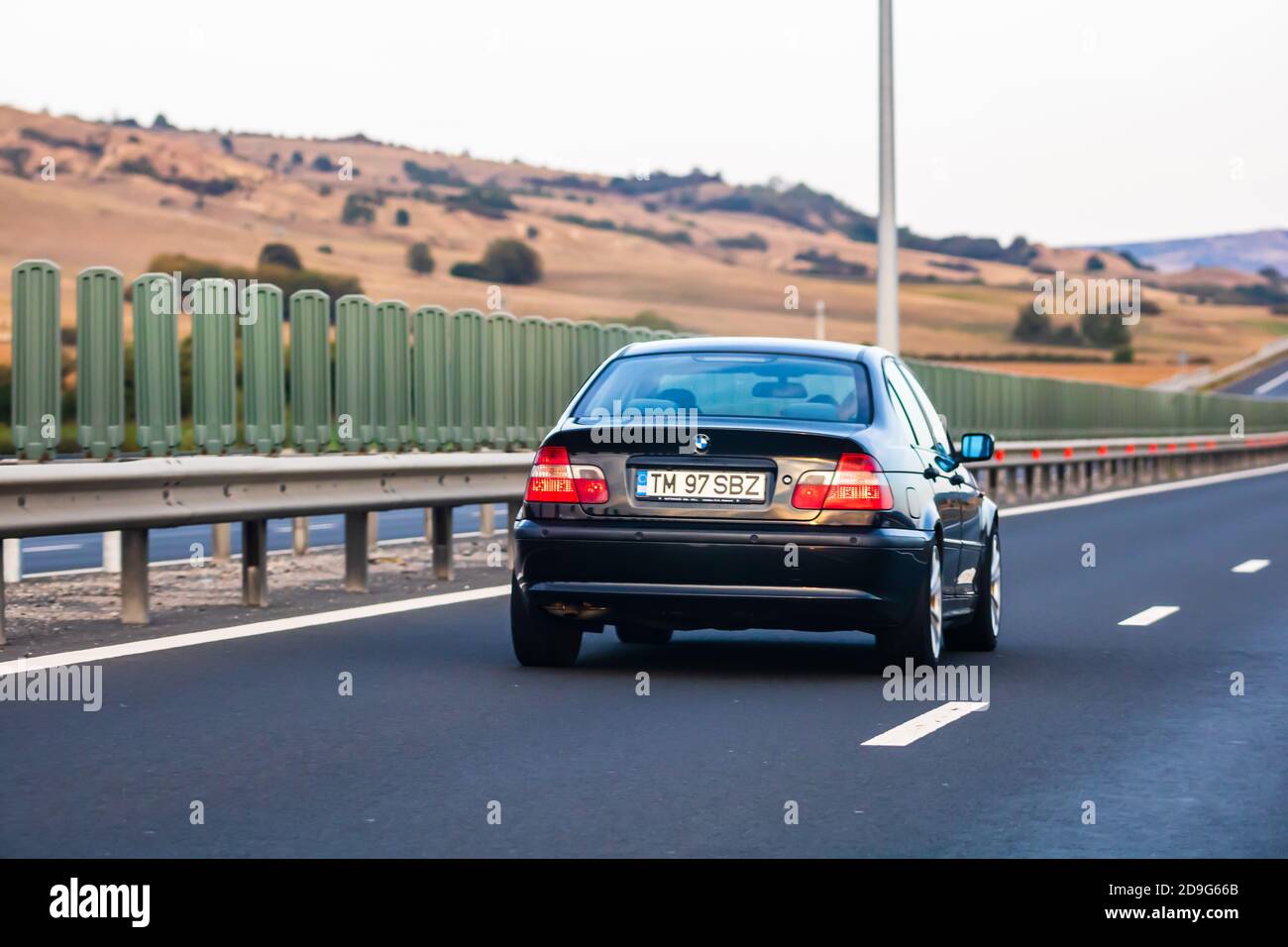 Traveling black car in motion on asphalt road, back view of car on ...