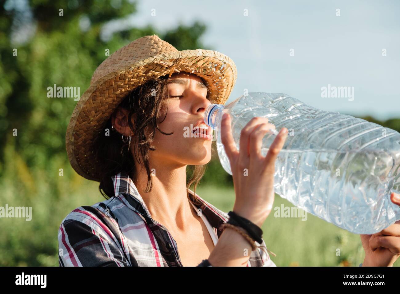 Farmer woman drinking water from plastic bottle during harvesting Stock ...