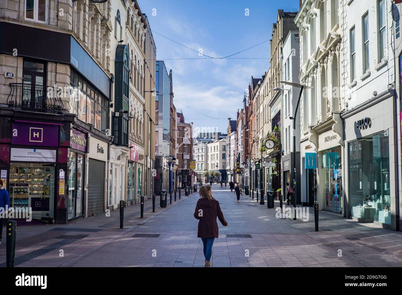 A woman walks alone along Grafton St., the main shopping street in ...